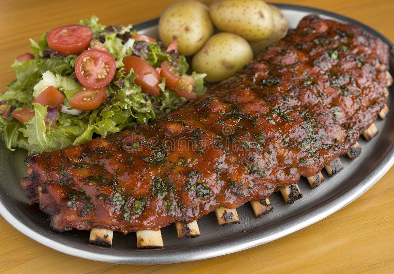 Closeup of a Rack of Ribs with a Side of Salad and Potatoes Stock Photo ...