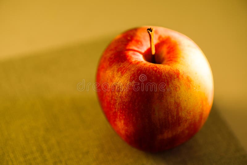 Closeup of a Red Apple Reflecting on the Table Under the Lights with a ...