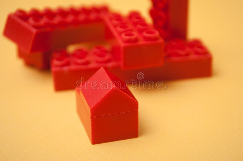 Red Plastic Bricks Construction on Yellow Background Stock Image ...