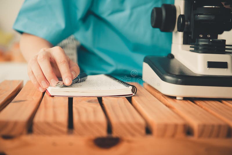 Closeup of Researcher Woman Using Microscope while Writing Note Stock ...