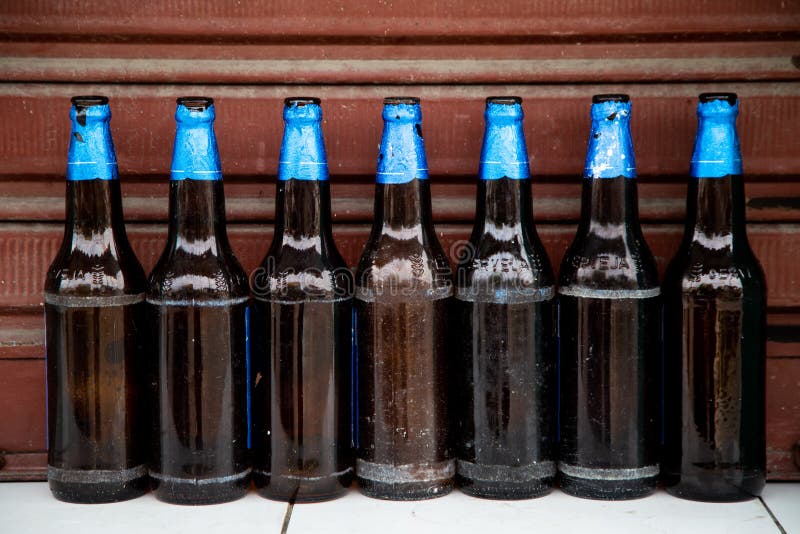 Closeup of a Row of Empty Ember Bottles with Blue Paint on the Neck ...