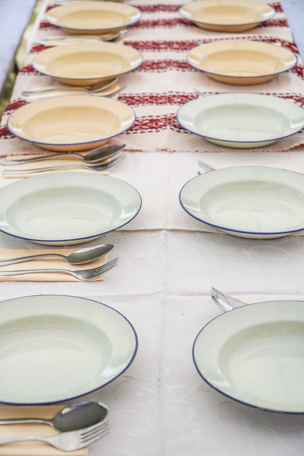 Row of Empty Enamel Plates on the Table Set for Dinner Stock Photo ...