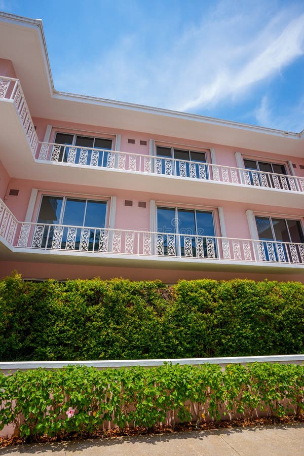 Closeup Section of a Pink Building with Green Bush Hedges Stock Photo ...