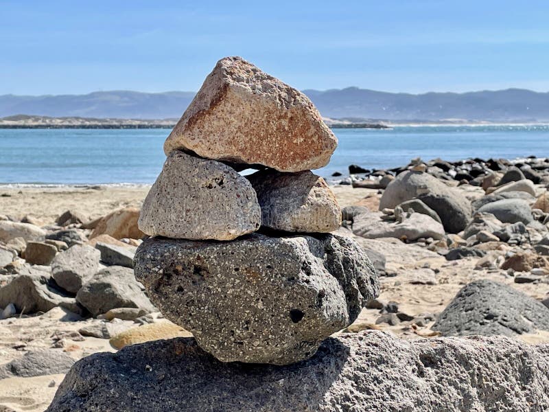 Closeup of Several Stacked Large Rocks on the Beach with the Water in ...