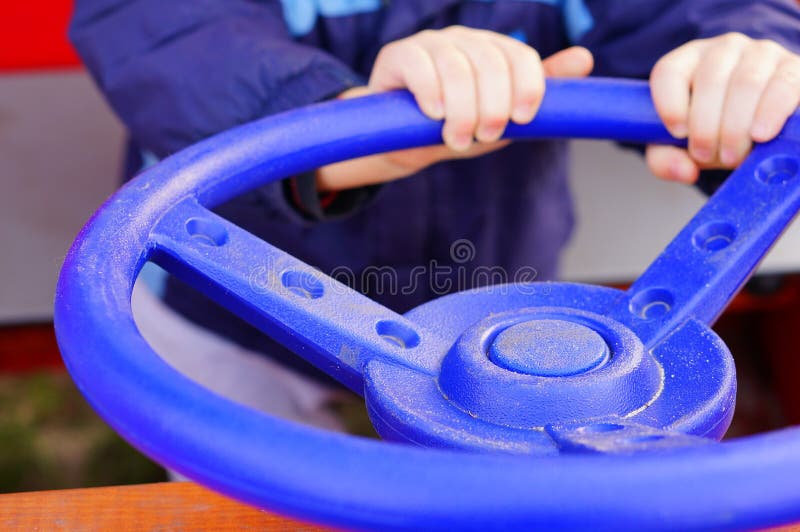 Closeup Shot of a Boy Holding on a Blue Toy Steering Wheel Stock Photo ...