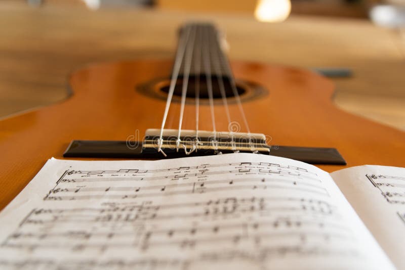Closeup Shot of a Brown Guitar with Music Notes Stock Photo - Image of ...