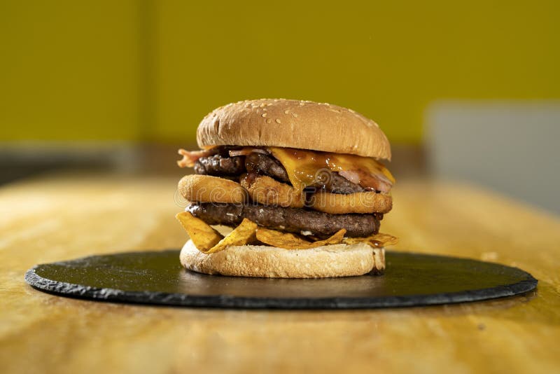 Closeup Shot of a Burger on a Black Round Board on a Wooden Table Stock ...