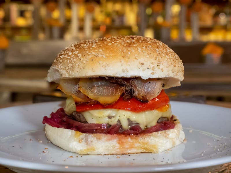 Closeup Shot of a Cheeseburger in White Plate with Blur Background ...