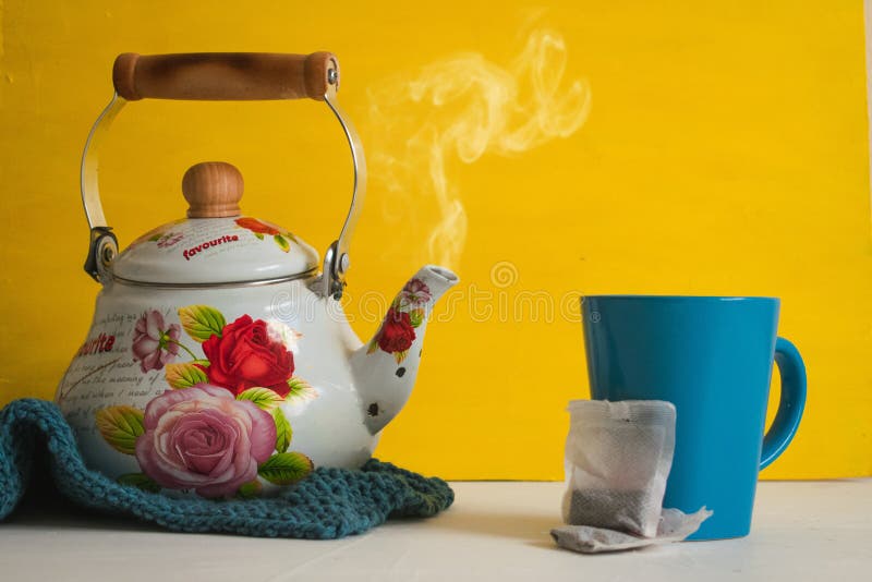 Closeup Shot of a Colorful Tea Kettle and a Blue Tea Cup with Tea Bags ...