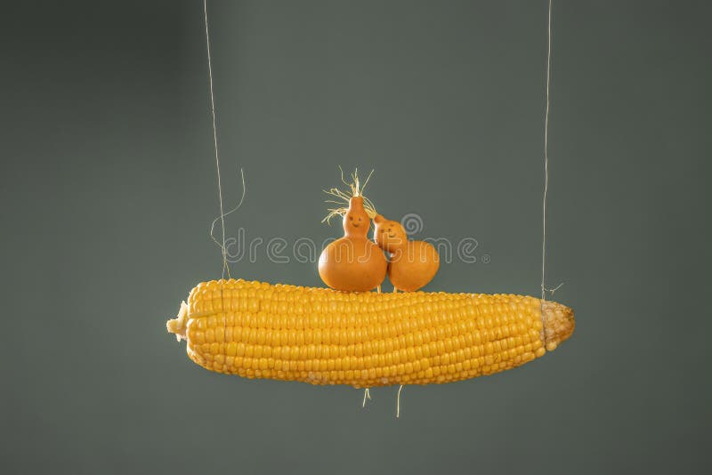 Closeup Shot of a Corn on the Cob Hanging on a String with Cute Figures ...
