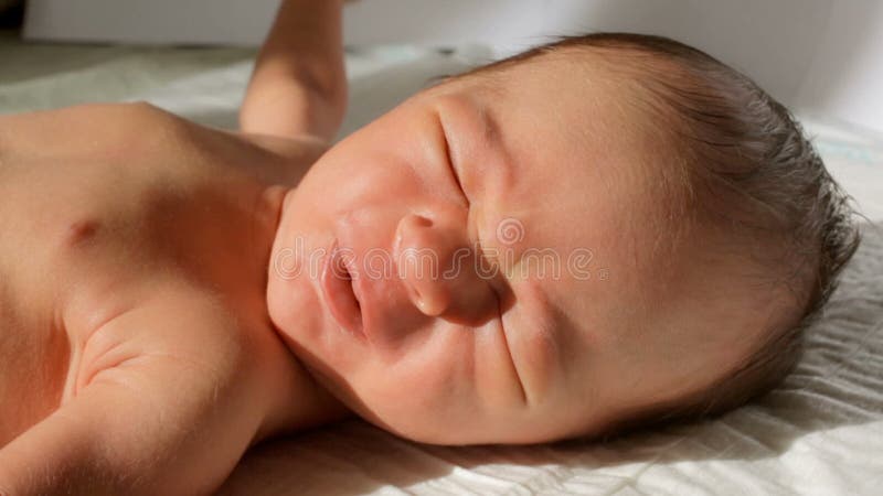 Closeup Shot of Crying Newborn Baby Lying on Bed in Sun Rays Stock ...