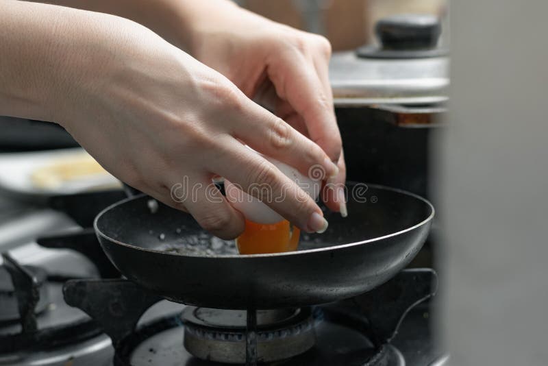 Closeup Shot of Female Hands Cracking Open an Egg into a Metal Pan ...