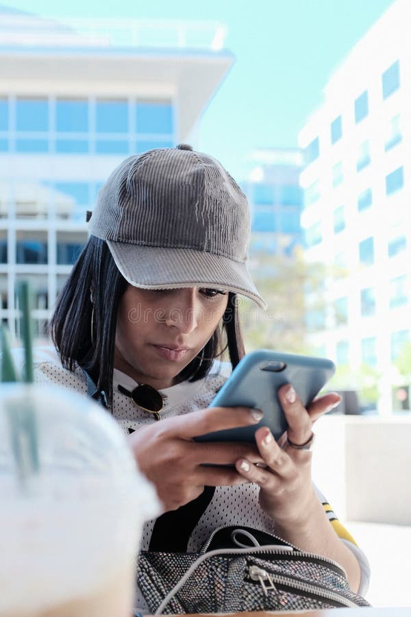 Closeup Shot of a Girl in a Cap Looking at Her Phone Stock Photo ...