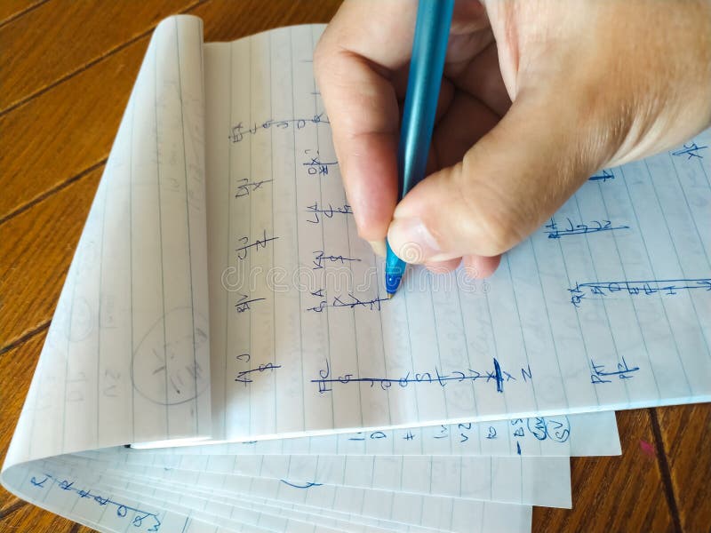 Closeup Shot of a Hand Writing Notes in a Notebook with a Blue Pen. the ...