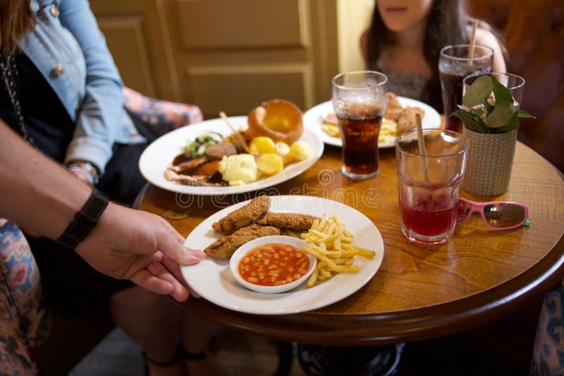 Closeup Shot of a Lunch Table with Different Dishes and People Talking ...