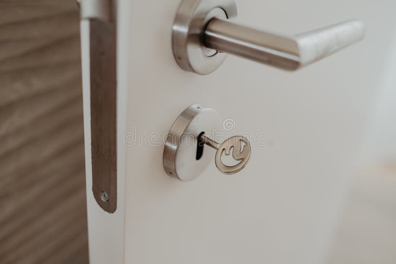 Closeup Shot of a Metal Handle and a Key on a White Door Stock Photo ...
