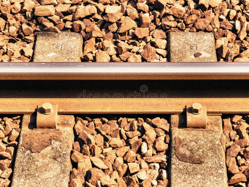 Closeup Shot of a Metal Railing Surrounded by Rocks on a Train Track ...