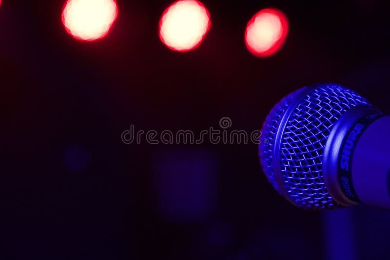Closeup Shot of a Microphone Set on a Stage during an Event with Lights ...