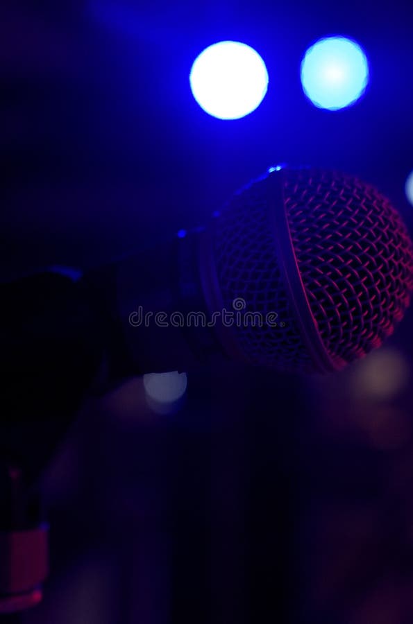 Closeup Shot of a Microphone Set on a Stage during an Event with Lights ...