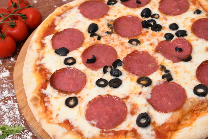 Closeup Shot of a Pepperoni Pizza with Olives on a Messy Kitchen Table ...