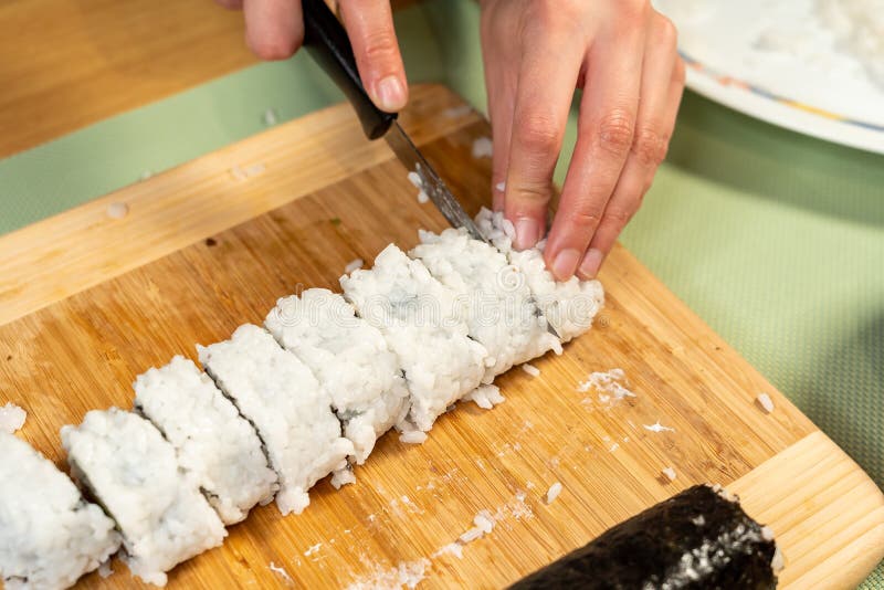 Closeup Shot of a Person Cutting Sushi Rolls Stock Photo - Image of ...