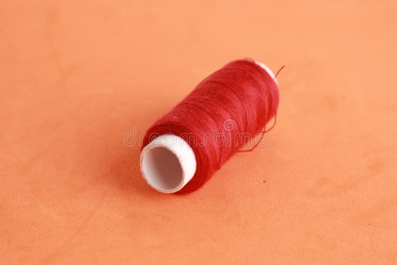 Closeup Shot of a Red Sewing Thread on an Orange Background Stock Image ...