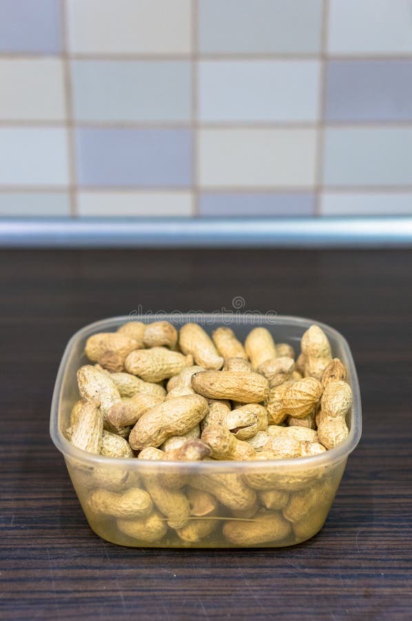 Closeup Shot of Roasted Peanuts in a Plastic Container on a Wooden ...