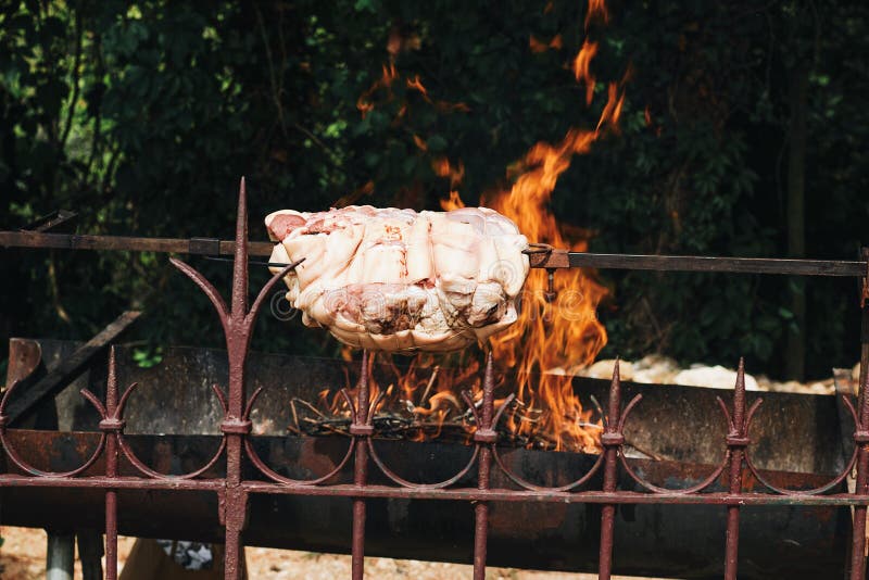 Closeup Shot of Roasting Meat on a Spit with Fire on the Background ...