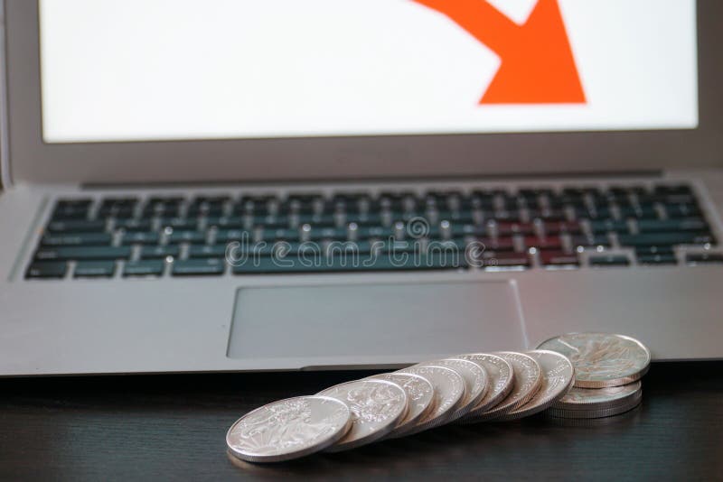 Closeup of Silver Coins with a Drop in Value on the Computer with Red ...