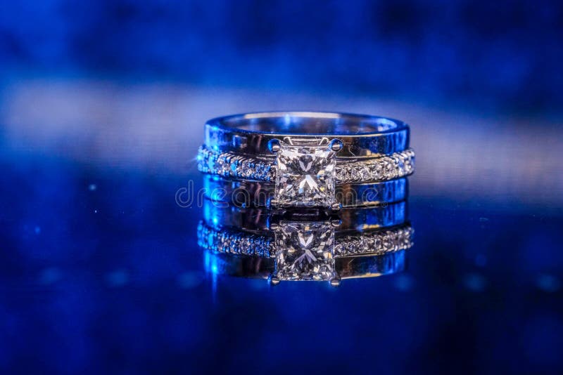 Closeup of a Silver Wedding Ring with Diamonds Reflecting on a Glass ...