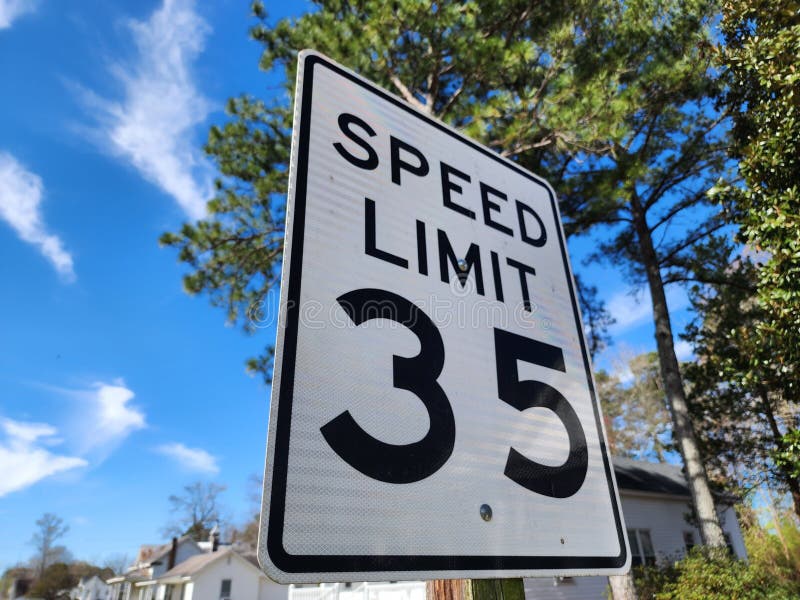 Closeup of 35 Speed Limit Road Sign Under the Blue Sky with a Blurry ... Closeup of 35 Speed Limit Road Sign Under the Blue Sky with a Blurry ...