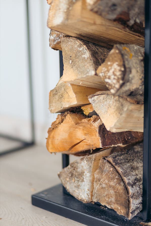 A Closeup of a Stack of Firewood in a Black Firewood Stand on Light ...