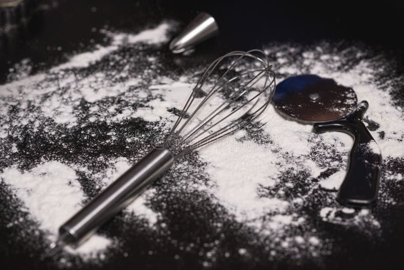 Closeup of Stainless Baking Tools on a Black Surface Dusted with Flour ...