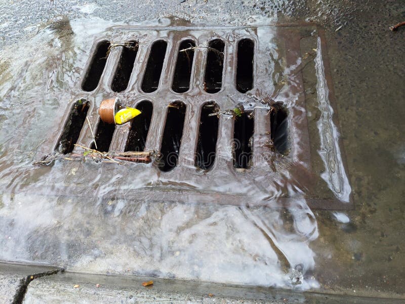 Closeup of a Storm Drain in the Ground with Soap and Water Going Down ...