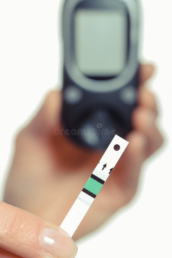 Closeup of Strip for Glucose Testing and Glucometer in Background ...