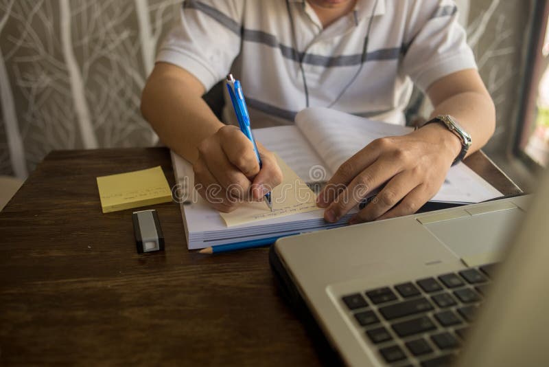 Close Up of Student Doing Homework Next To Laptop Stock Photo - Image ...