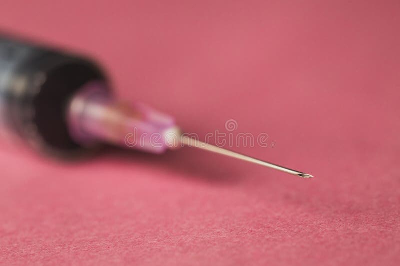 Closeup of a Syringe with a Needle on a Pink Background Stock Photo ...