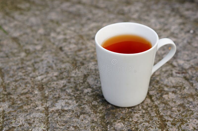 Closeup of Tea in a White Cup on the Ground Under the Lights with a ...