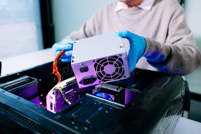 Closeup of Technician with Gloves Installing PSU into Computer Case, Symbolizing Hardware ...