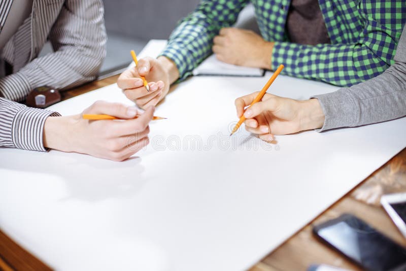 Closeup of Three Pairs of Hands Working on a New Project. the Drawing ...