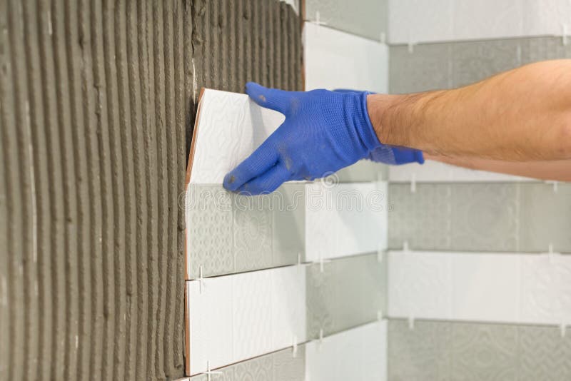 Closeup of Tiler Hand Laying Ceramic Tile on Wall in Kitchen ...