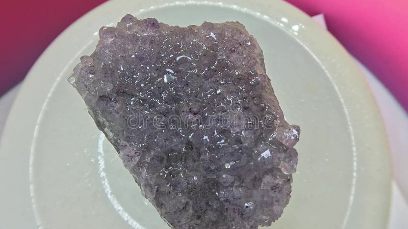 Closeup Top View of an Amethyst Quartz Stone Rotating on a White Small ...