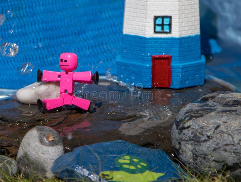 Closeup of Toy Stick Figures Playing on Wet Rocks. Stock Image - Image ...