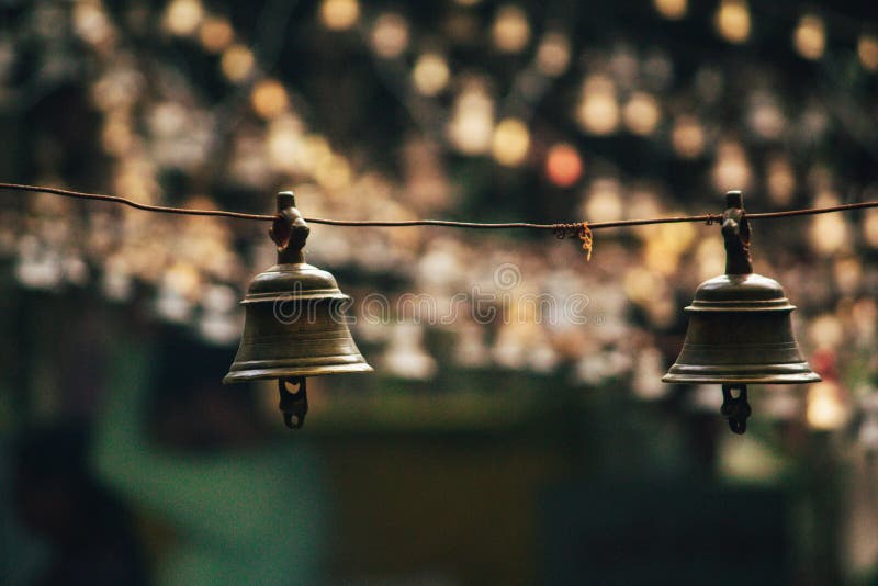 Closeup of Two Bells Hanging Against the Blurred Lights Background ...