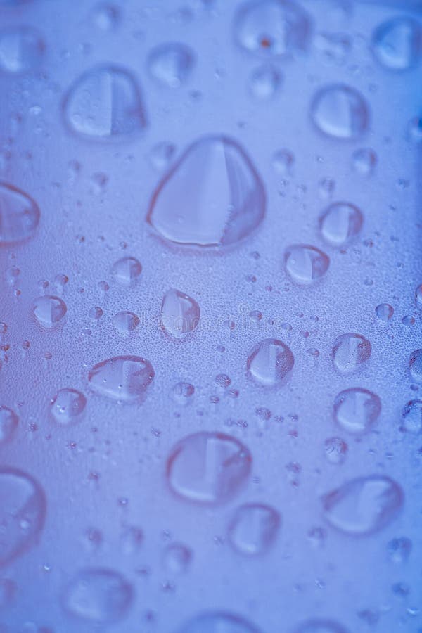 Closeup Vertical Shot of Water Drops on a Blue Surface Stock Image ...