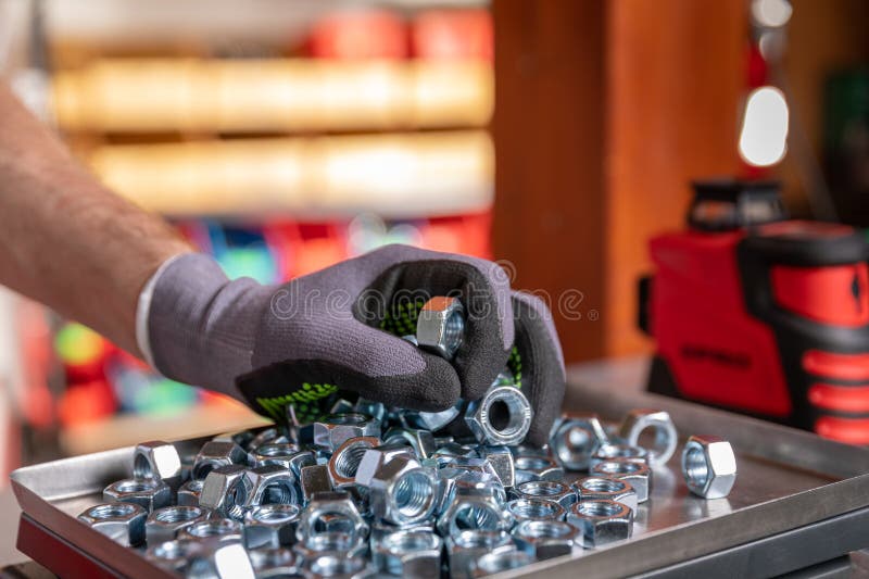 A Closeup View of a Hand Meticulously Sorting Various Metal Bolts and ...