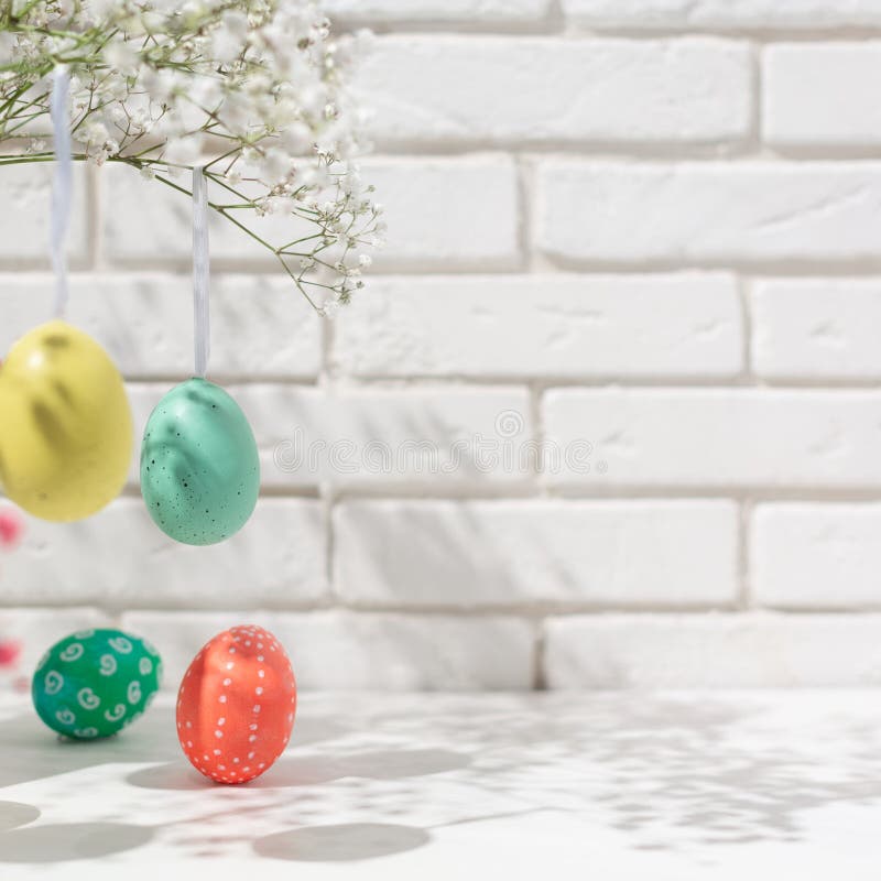 Closeup View of Hanging Fake Eggs on Table with Brick Wall with Copy ...