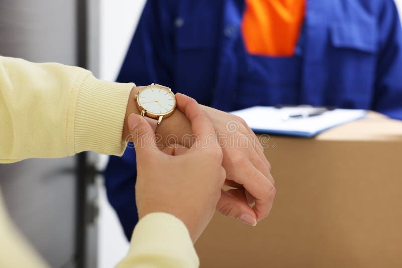 Closeup View of Woman Checking Time Near Courier with Parcel Stock ...