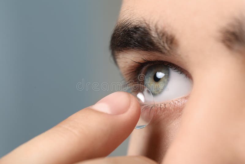 Closeup View of Young Man Putting in Contact Lens on Grey Background ...