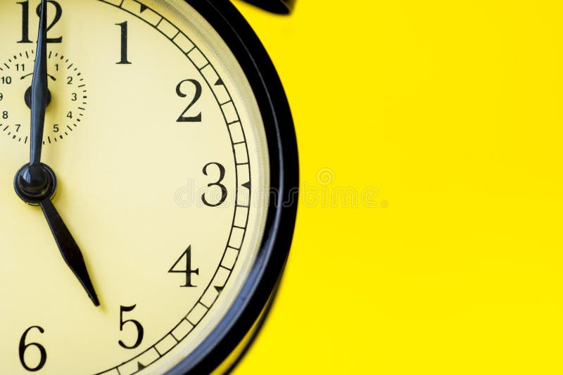 Closeup of a Vintage Analog Black Clock on a Yellow Background ...